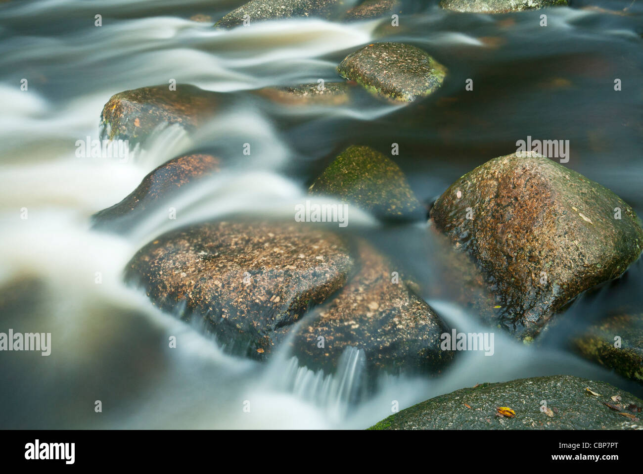 Water rushing over rocks at East Dart river, captured with slow shutter ...