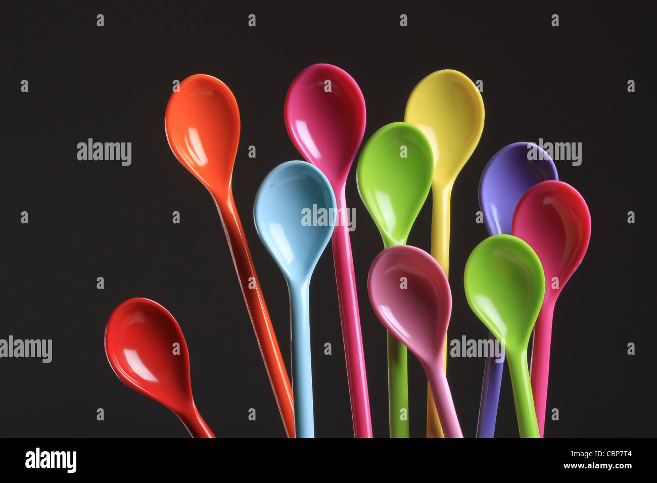 Spoons of different colors on even background Stock Photo - Alamy