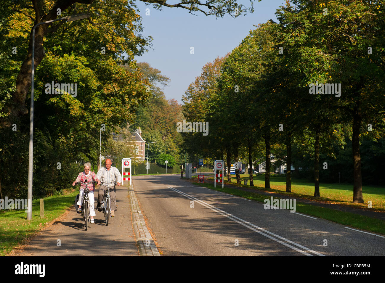 Village Muiderberg with couple at the bike Stock Photo - Alamy