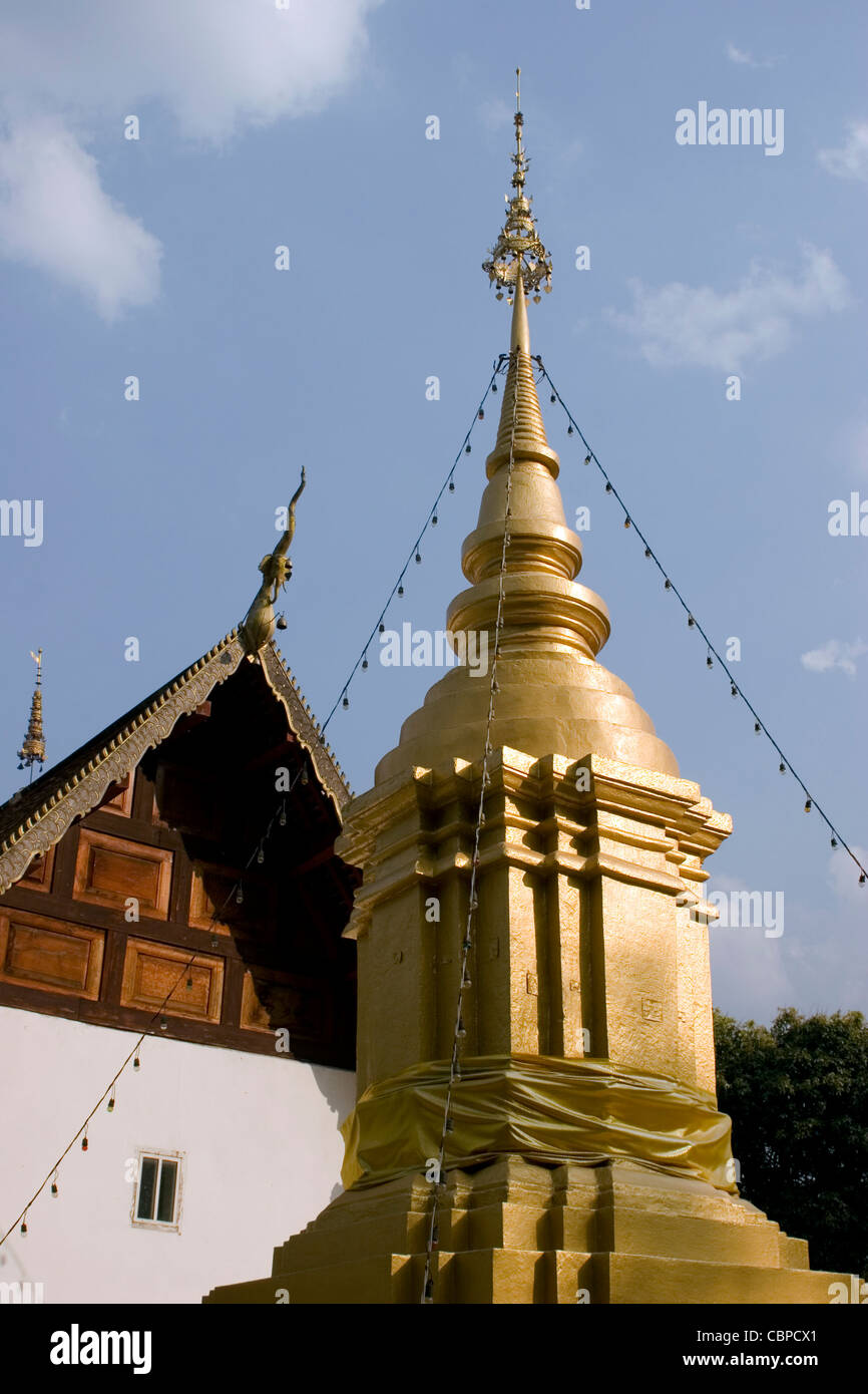 A gold stupa at a Buddhist temple is standing near a pagoda near Pai ...
