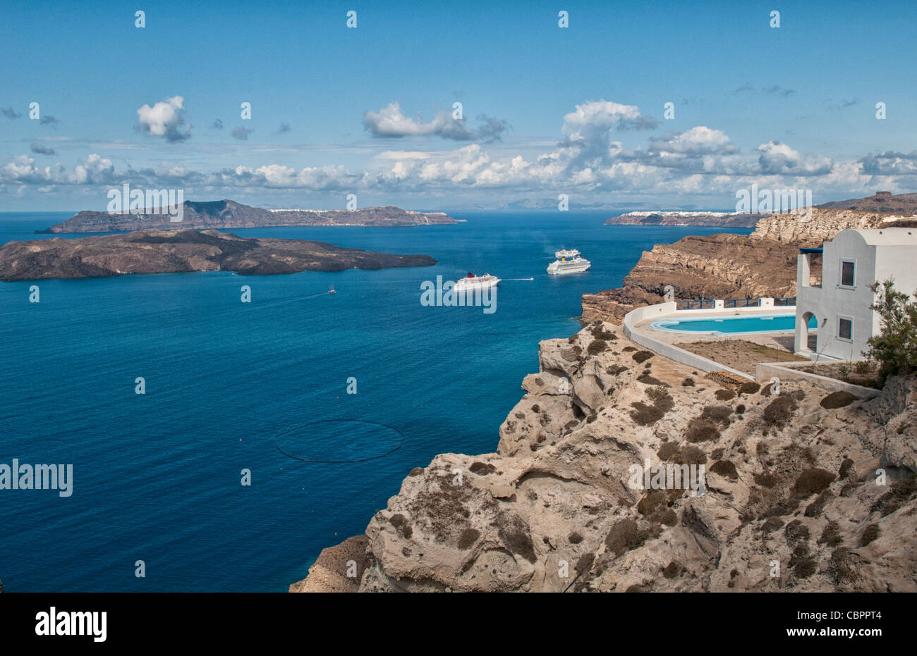 Scene of ocean and cliffs with home with pool in Athinios in Santorini ...