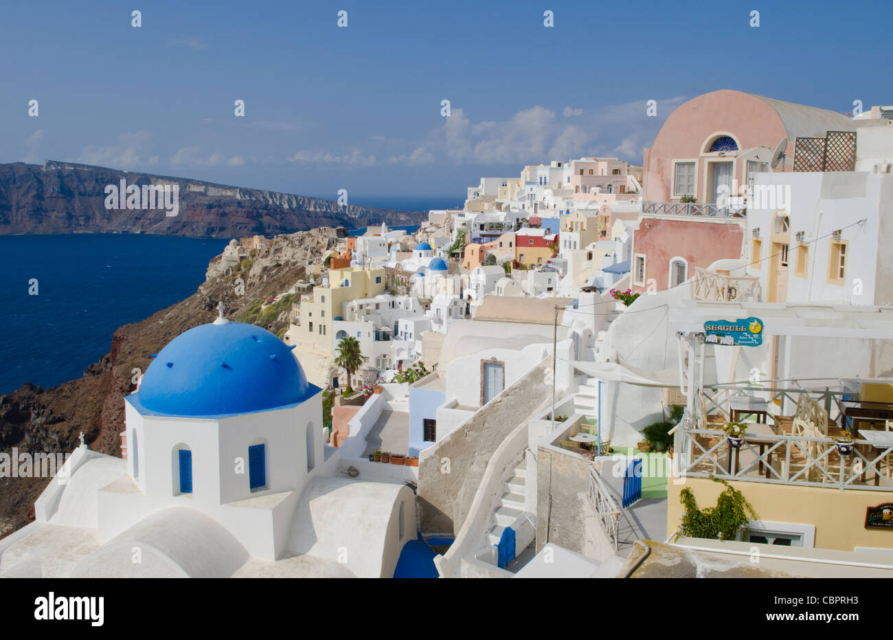 White buildings with steep slope with blue dome churches on mountain in ...