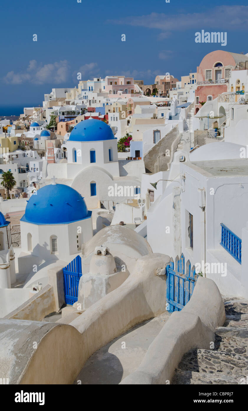 White buildings with steep slope with blue dome churches on mountain in ...