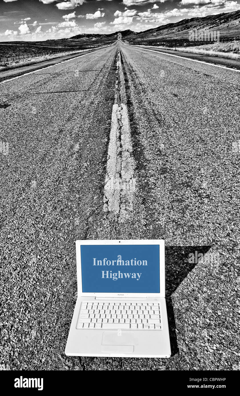 Computer in middle of remote road with Information Highway with ...