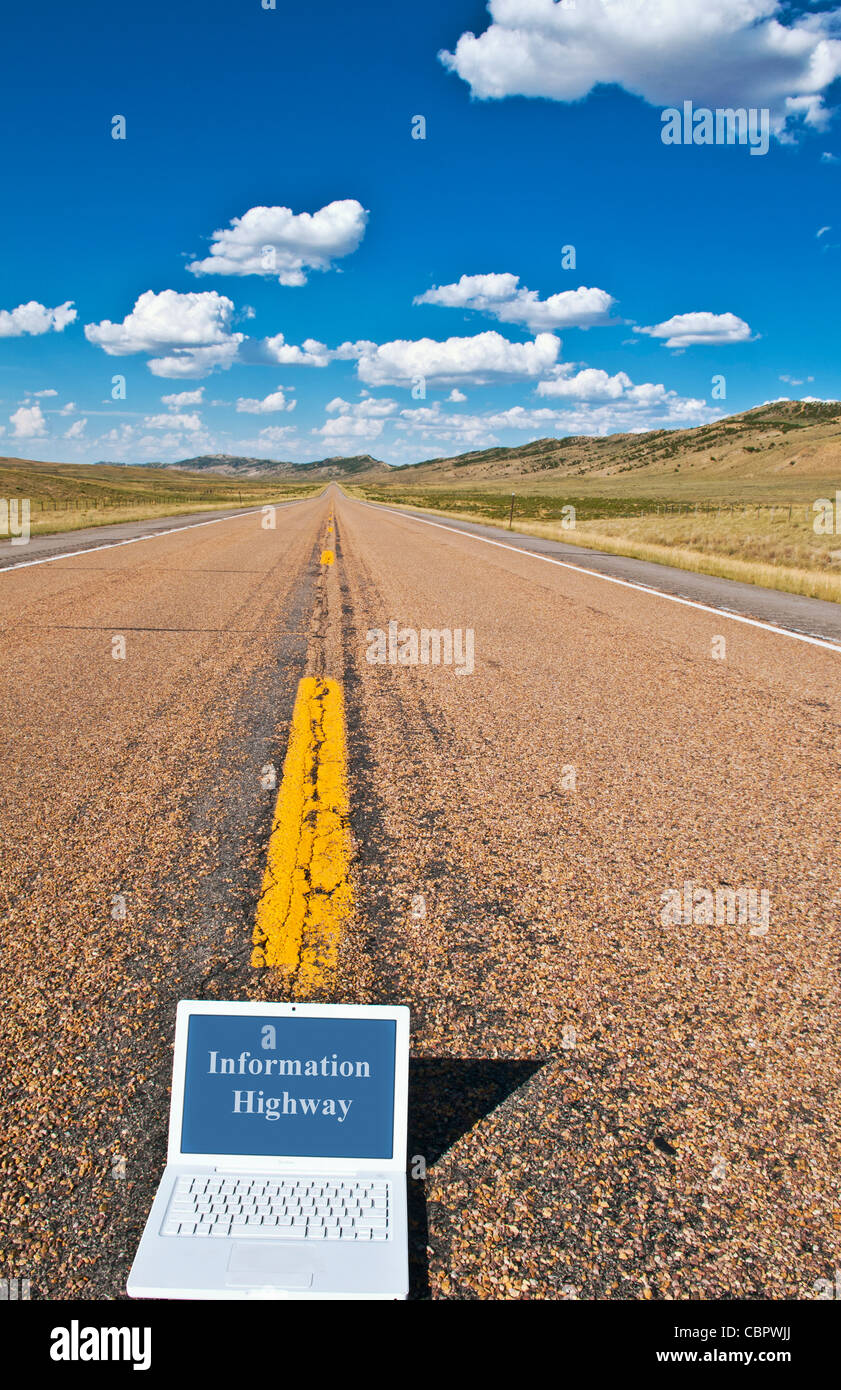 Computer in middle of remote road with Information Highway with ...
