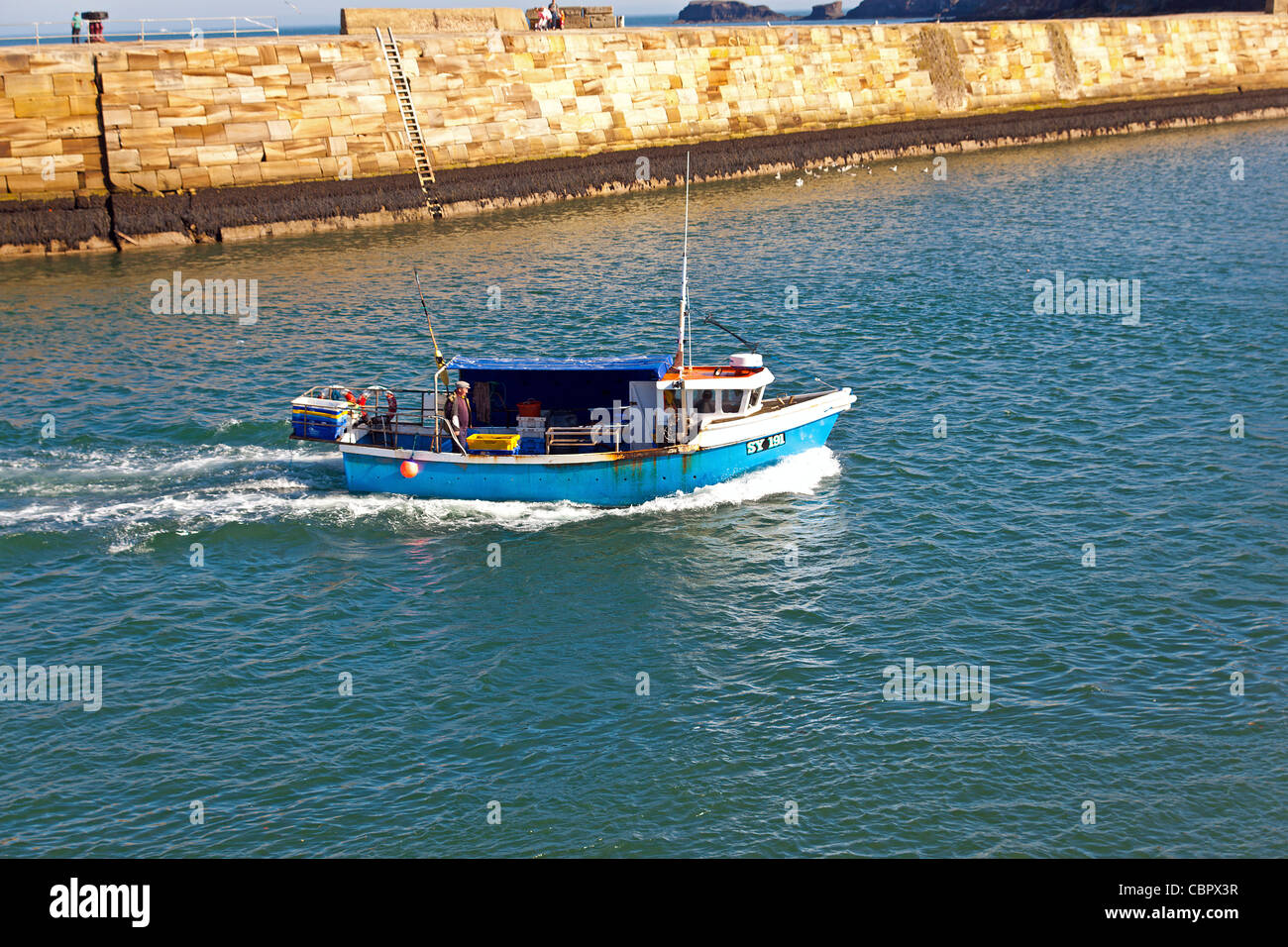 Fishing boat returning to Whitby Harbour Stock Photo - Alamy