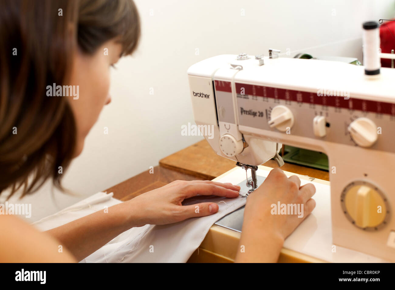 Woman using sewing machine Stock Photo - Alamy