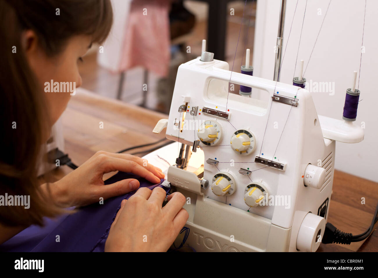 Woman using sewing machine Stock Photo - Alamy