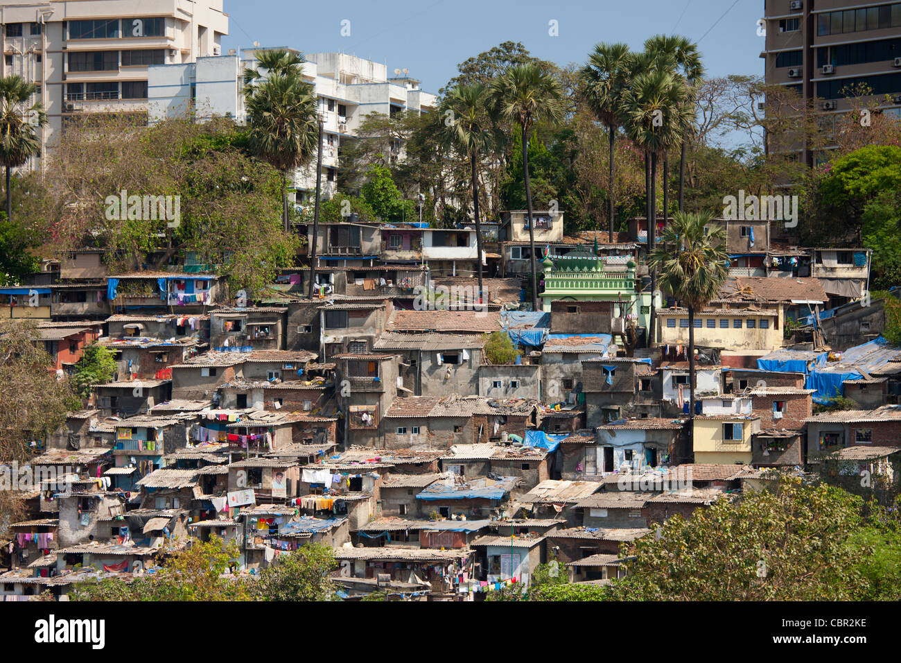 Slum housing and slum dwellers next to apartment blocks in Bandra area ...