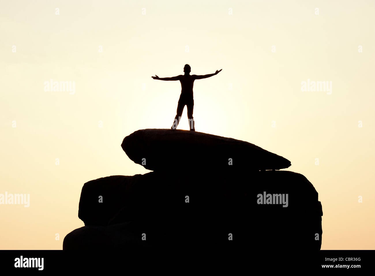 Indian man standing on a rock embracing the sun. Silhouette. India ...