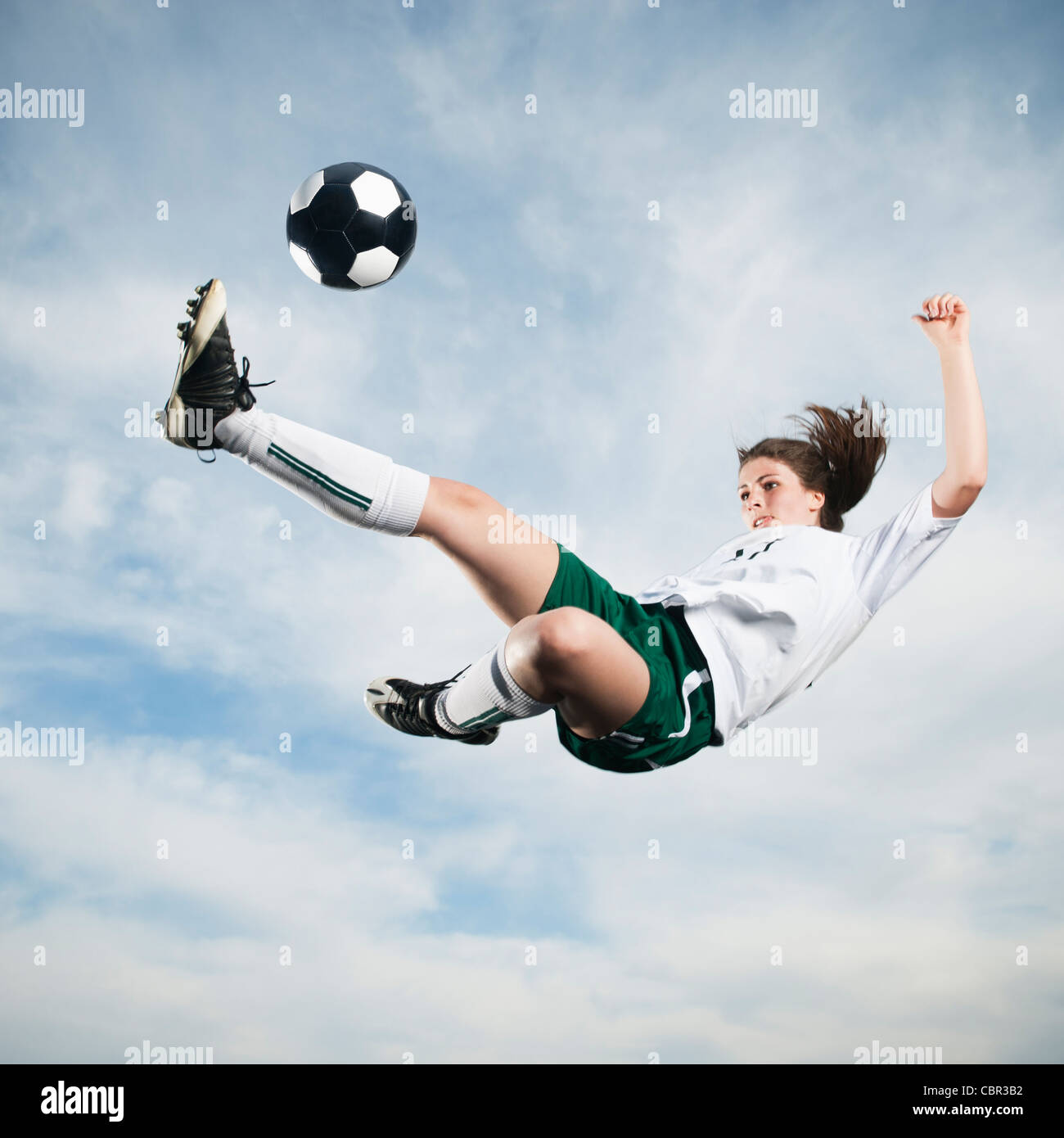 Caucasian teenager kicking soccer ball in mid-air Stock Photo - Alamy