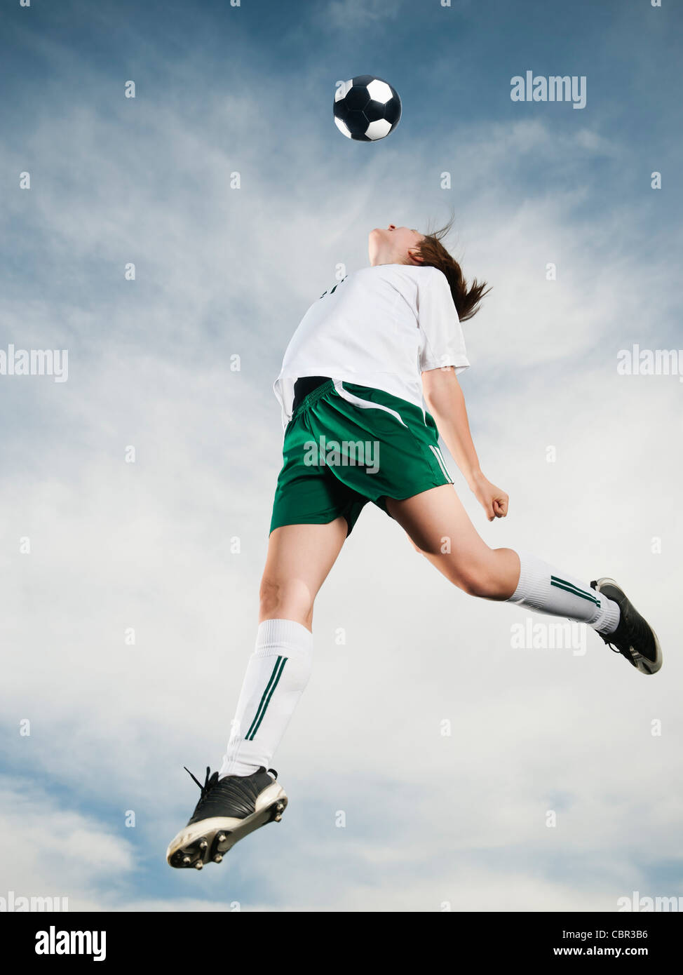 Caucasian teenager heading soccer ball in mid-air Stock Photo - Alamy