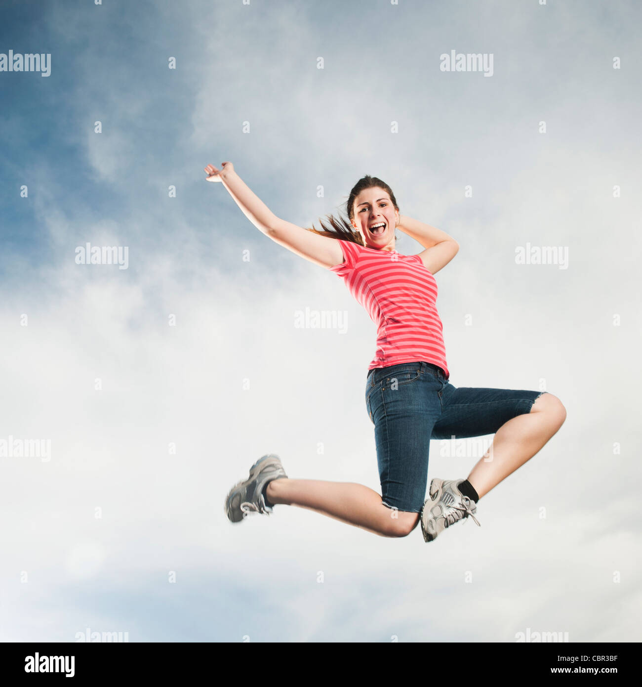 Caucasian teenager jumping in air Stock Photo - Alamy
