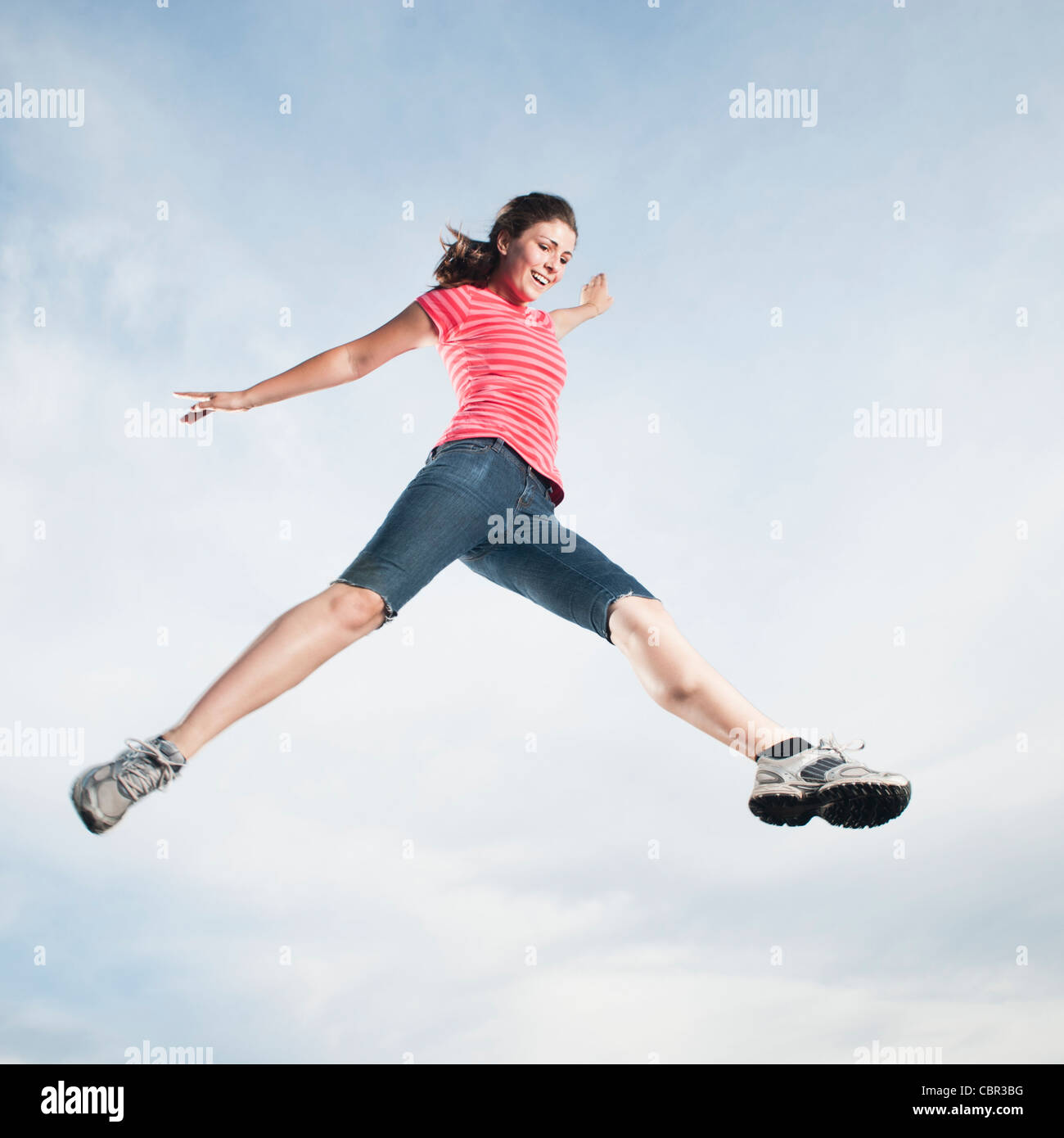 Caucasian teenager jumping in air Stock Photo - Alamy