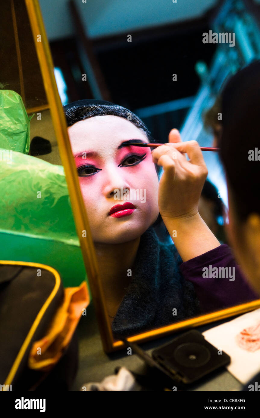A Chinese opera performer putting makeup in the dressing room Stock ...