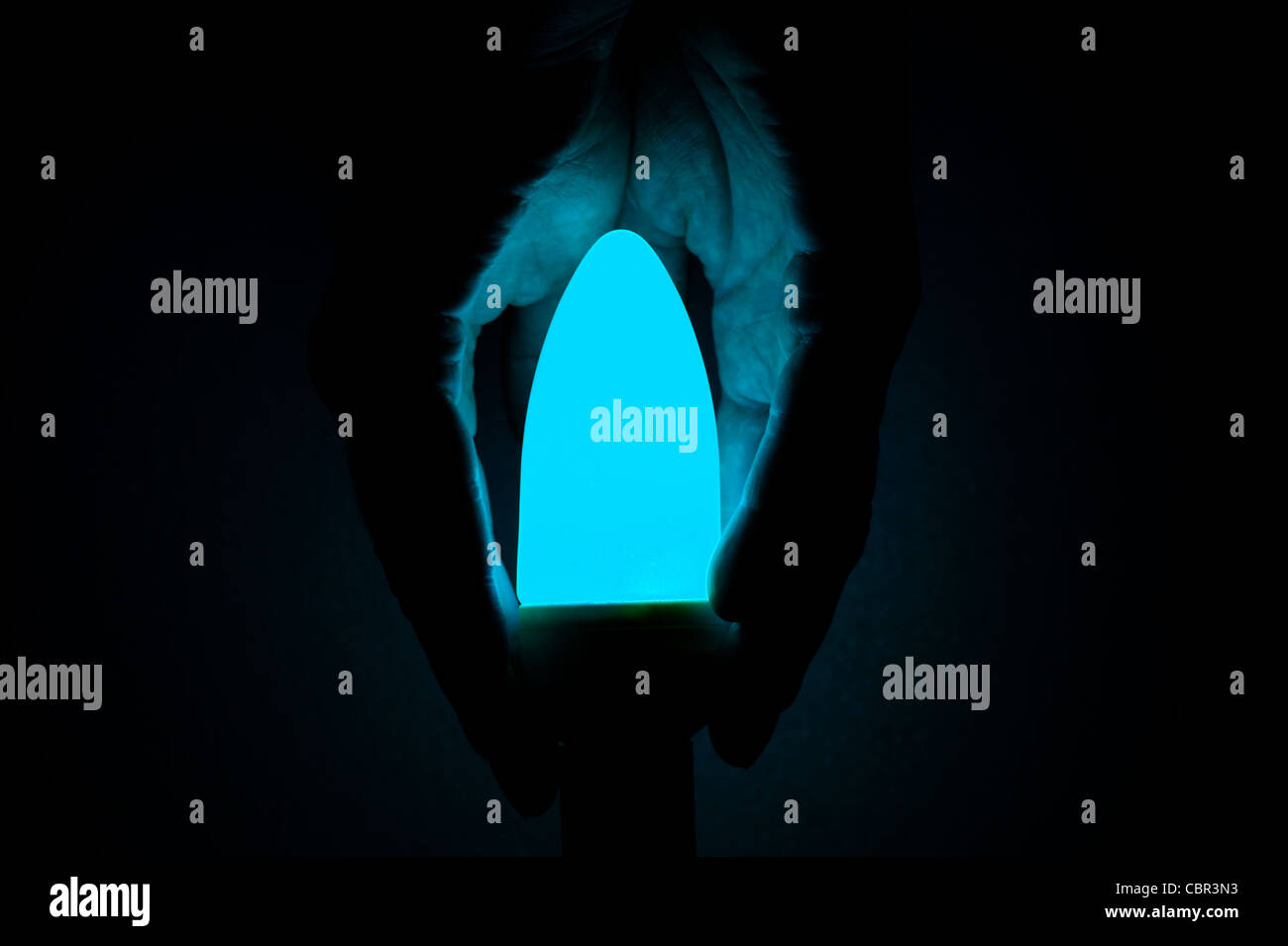 hand security luminous bulb on black background Stock Photo - Alamy