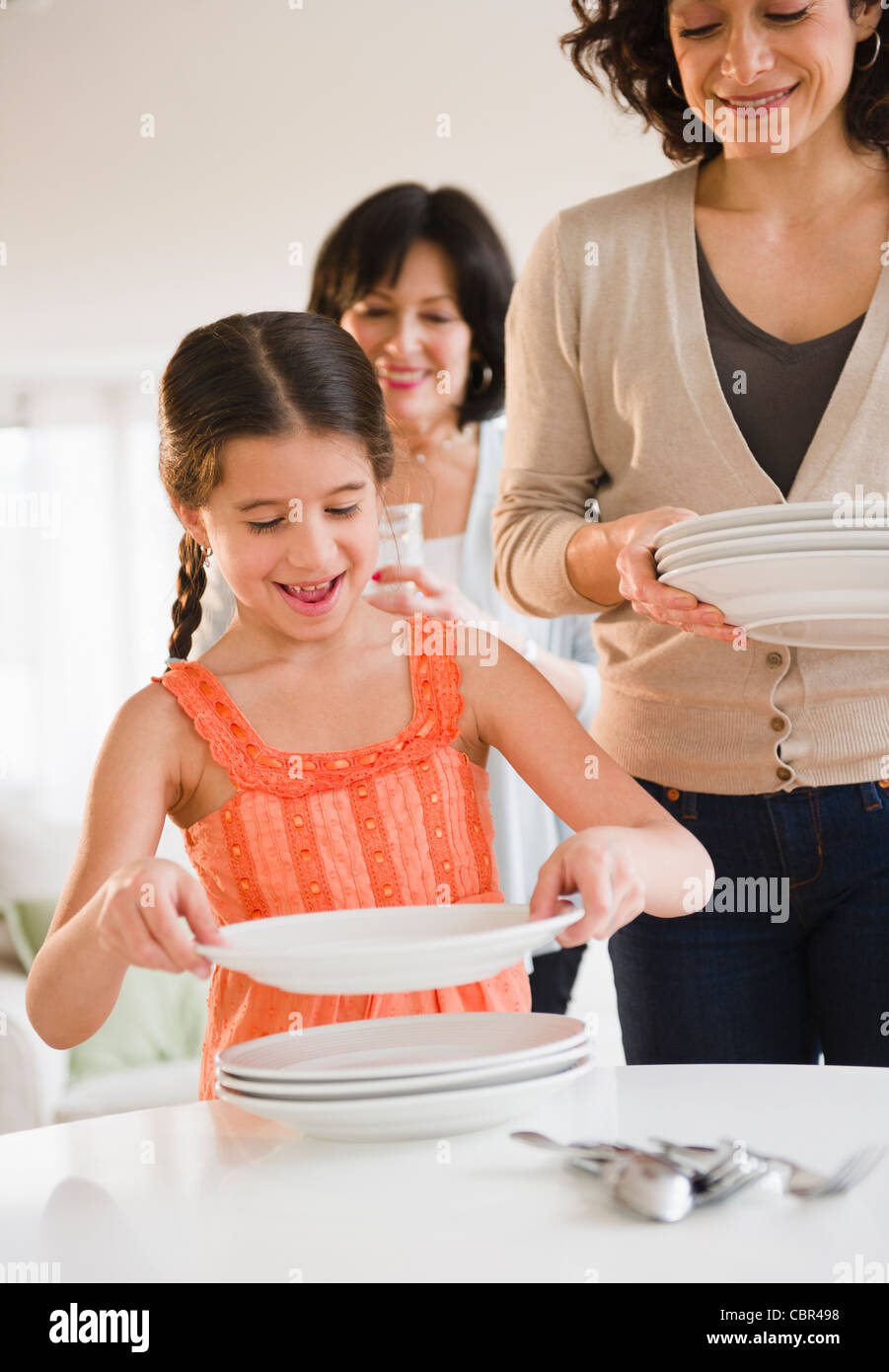Family setting the table together Stock Photo - Alamy