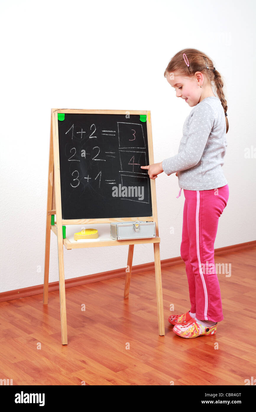 Cute girl doing the math on chalkborard Stock Photo - Alamy