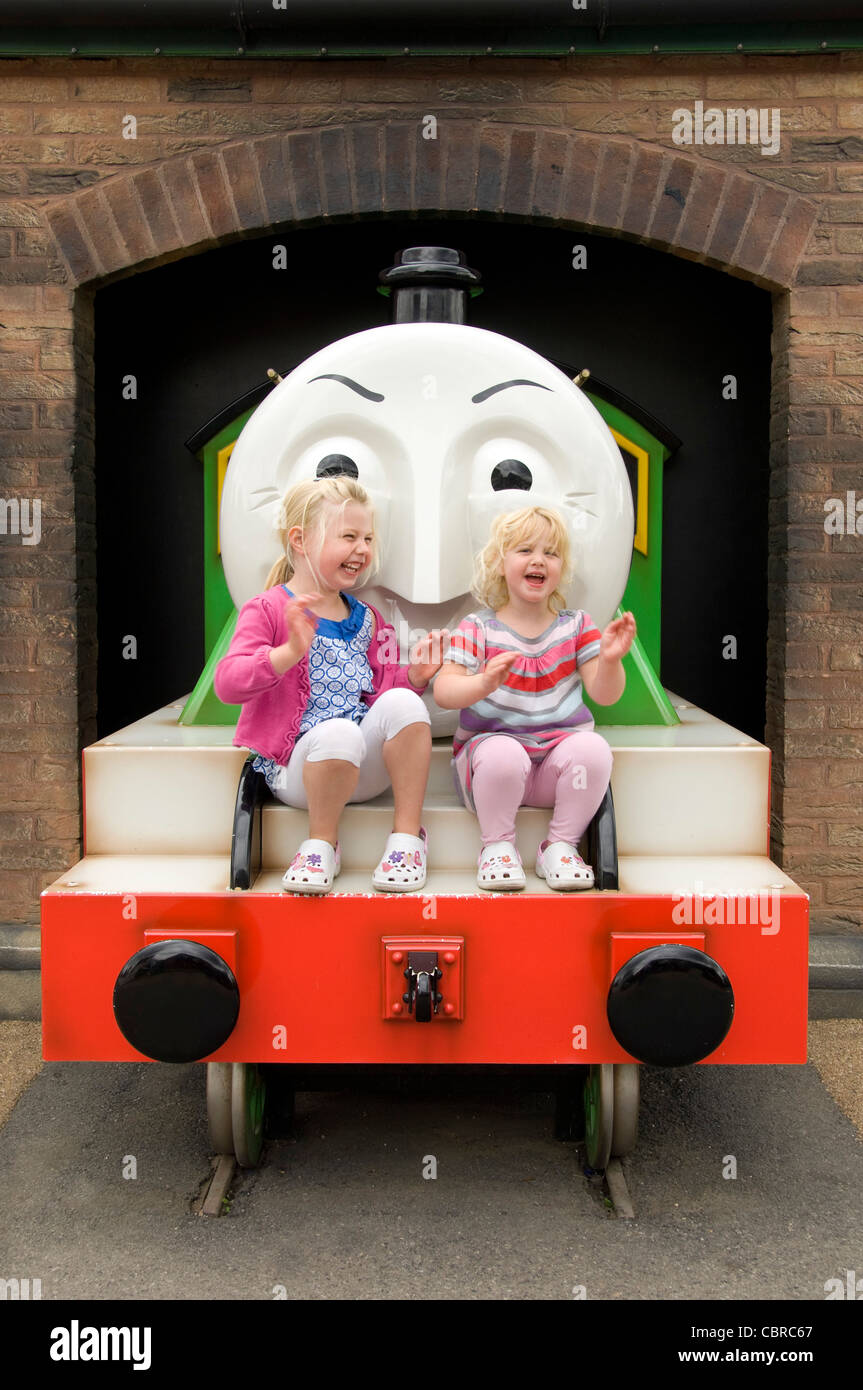 Vertical portrait of two little girls laughing and having fun sitting ...