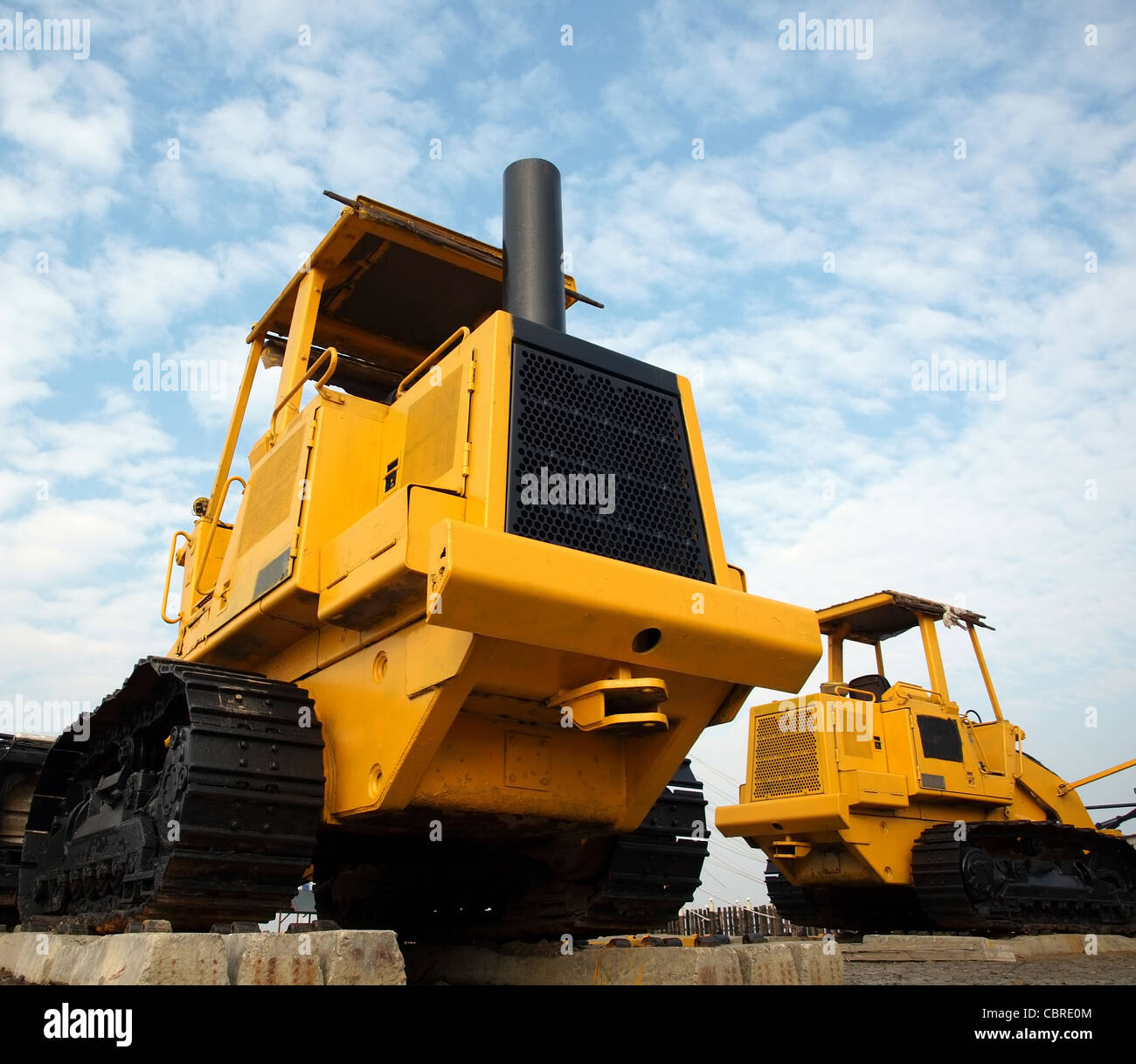 Heavy earth moving construction machinery is resting on concrete ...