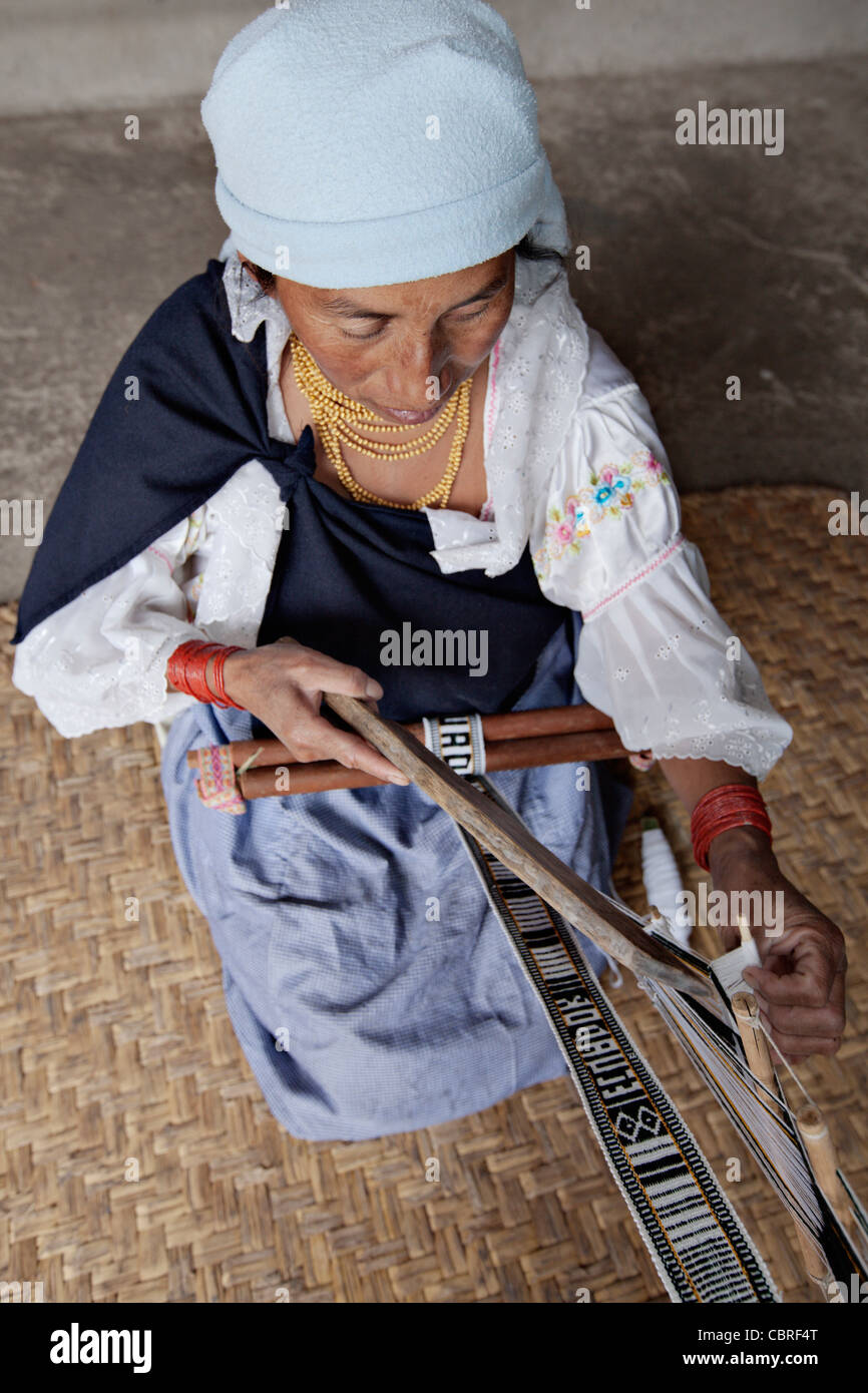 Indigenous woman weaving a traditional belt in a village near Otavalo ...
