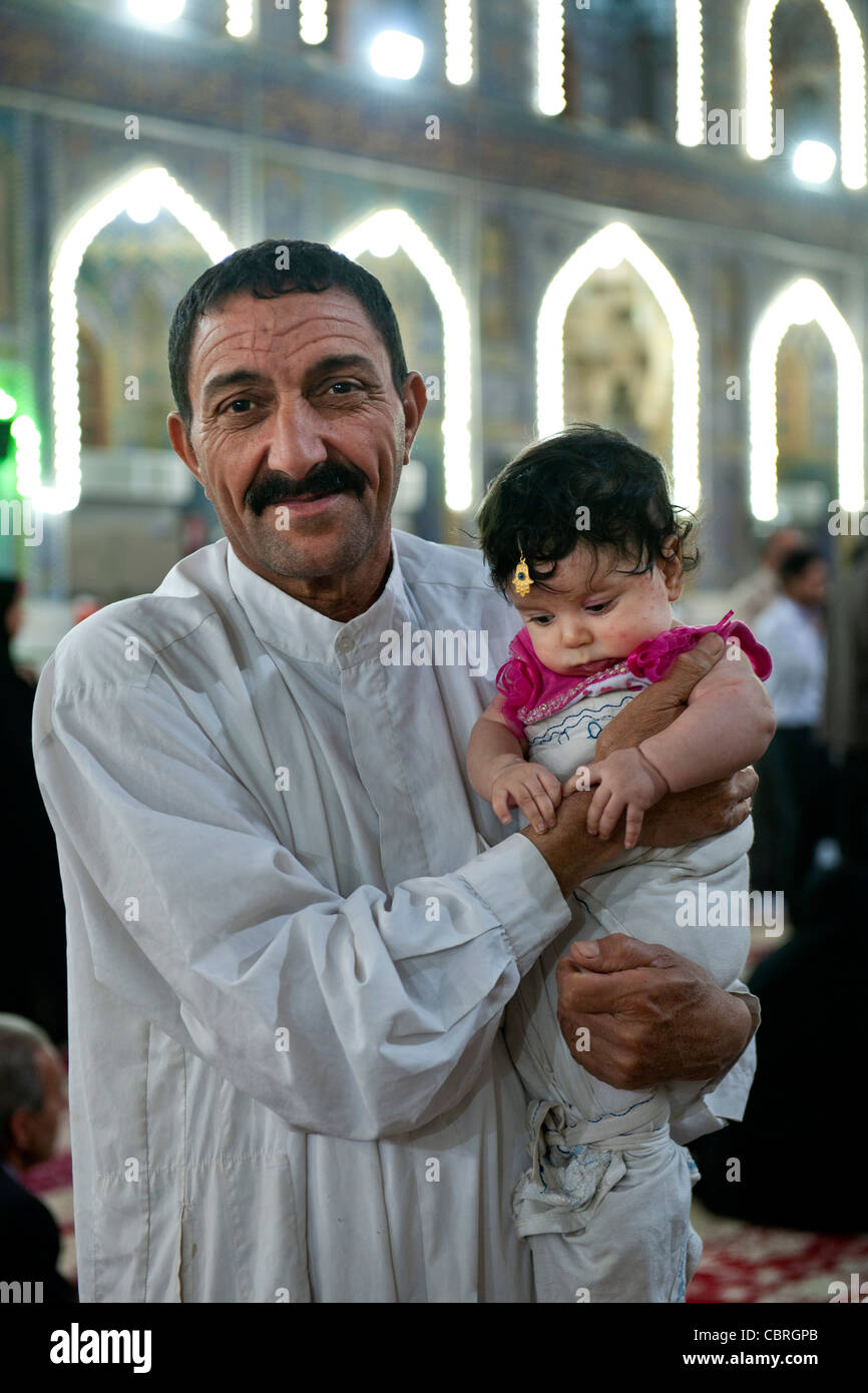 Worshiper with his child at the Al Abbas Mosque in Karbala, Iraq. A ...