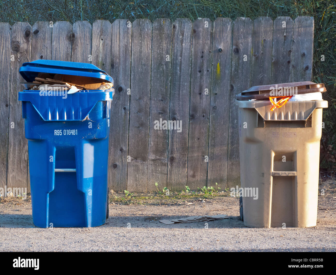 Two containers, one for recycle and the other for trash sit by the ...