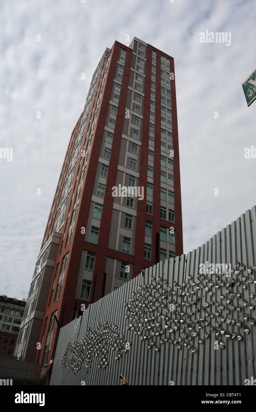 Red brick skyscraper rising above silver metal fence with ornate street ...