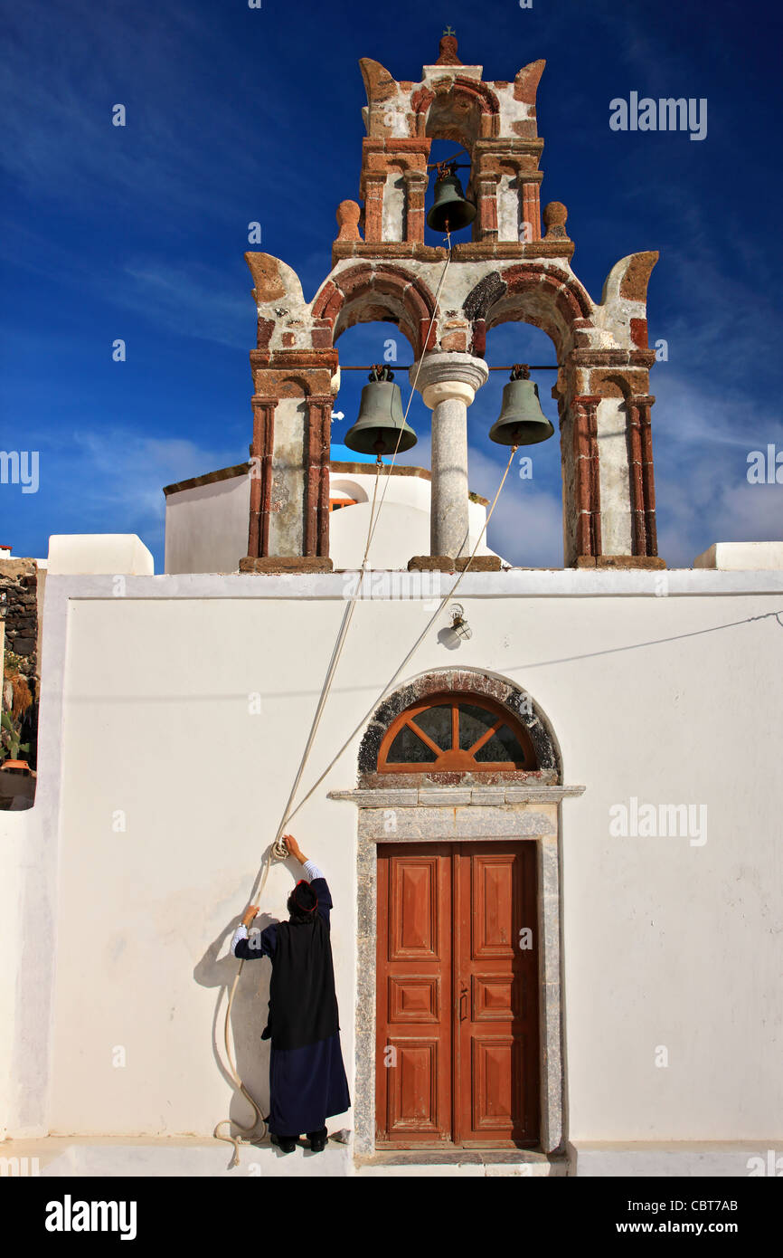 A Greek Orthodox priest ready to toll the bells of a church in ...