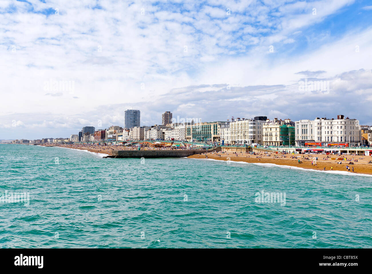 Sun bathers and swimmers relaxing on the ocean beach in Brighton ...