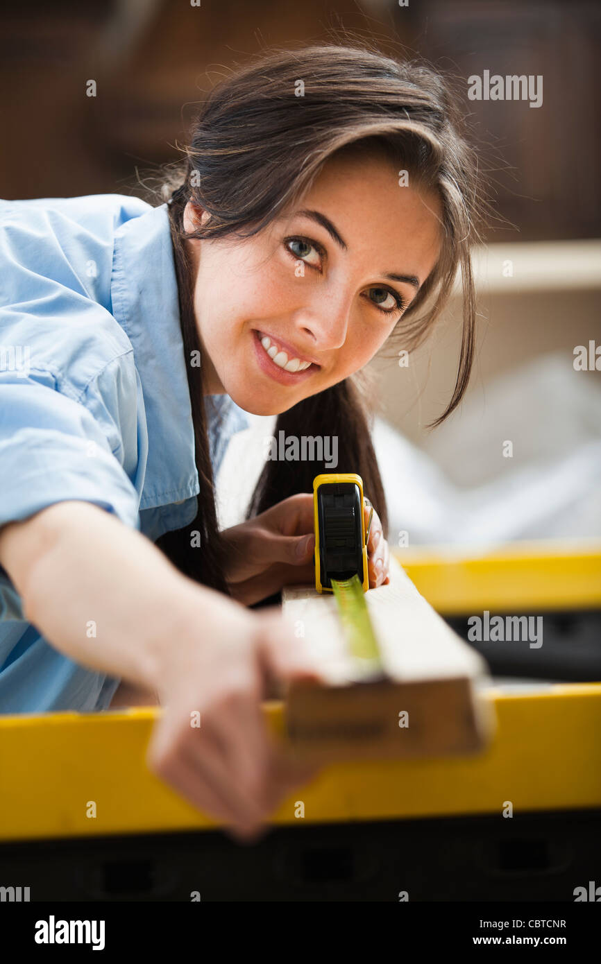 Caucasian woman measuring wood Stock Photo - Alamy