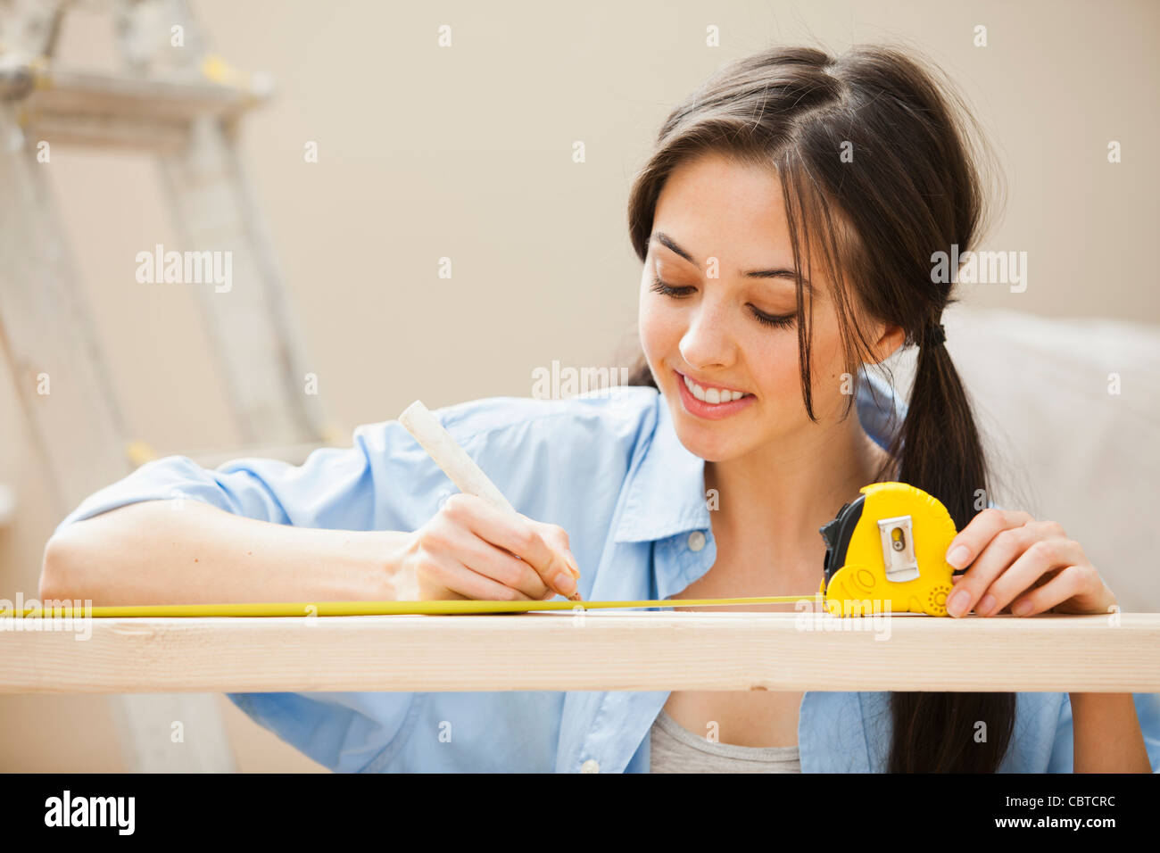 Caucasian woman measuring wood Stock Photo - Alamy