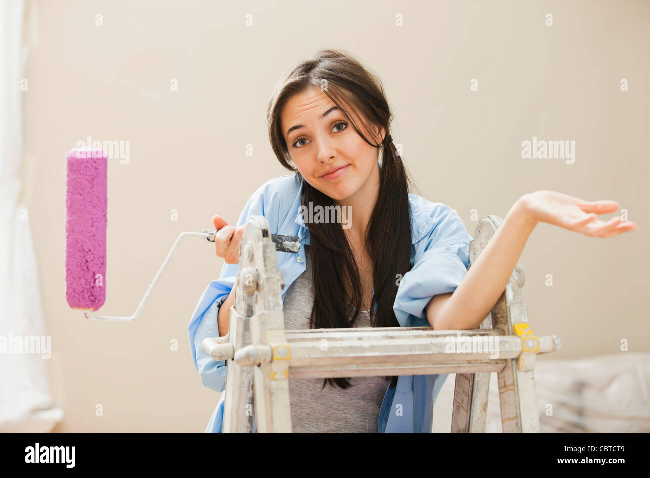 Caucasian woman holding paint roller Stock Photo - Alamy