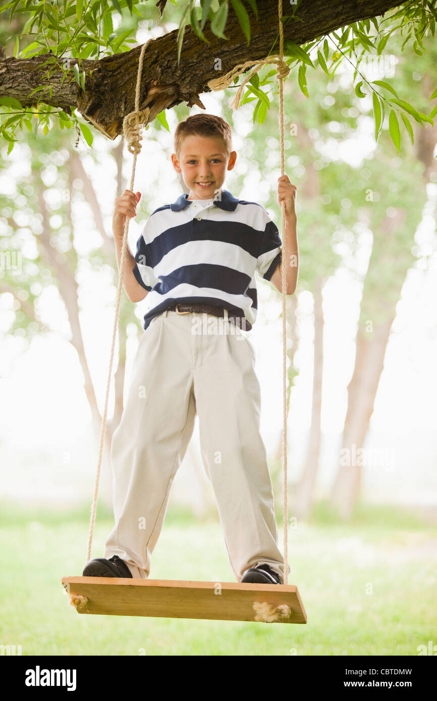 Caucasian boy swinging on swing Stock Photo - Alamy