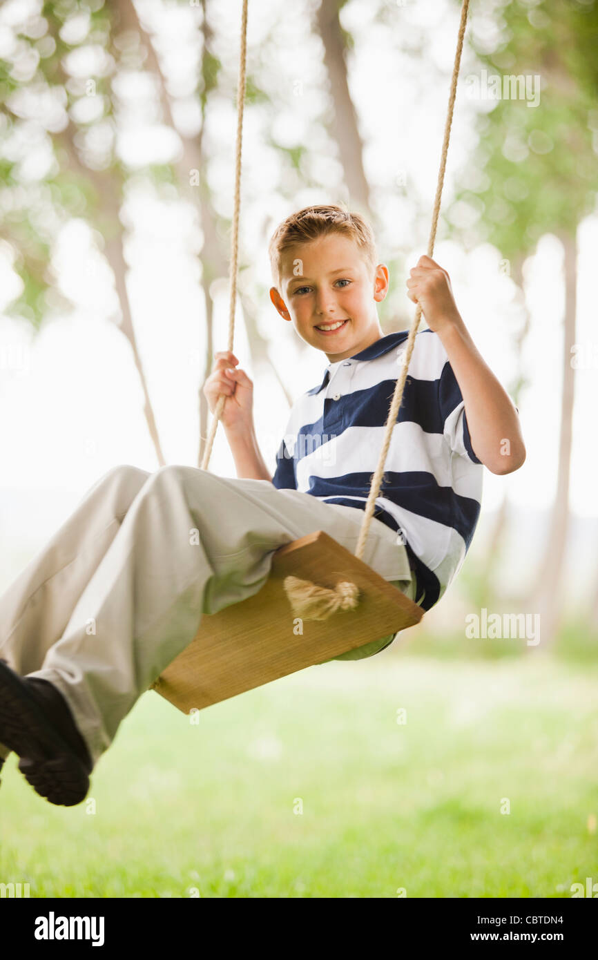 Caucasian boy swinging on swing Stock Photo - Alamy
