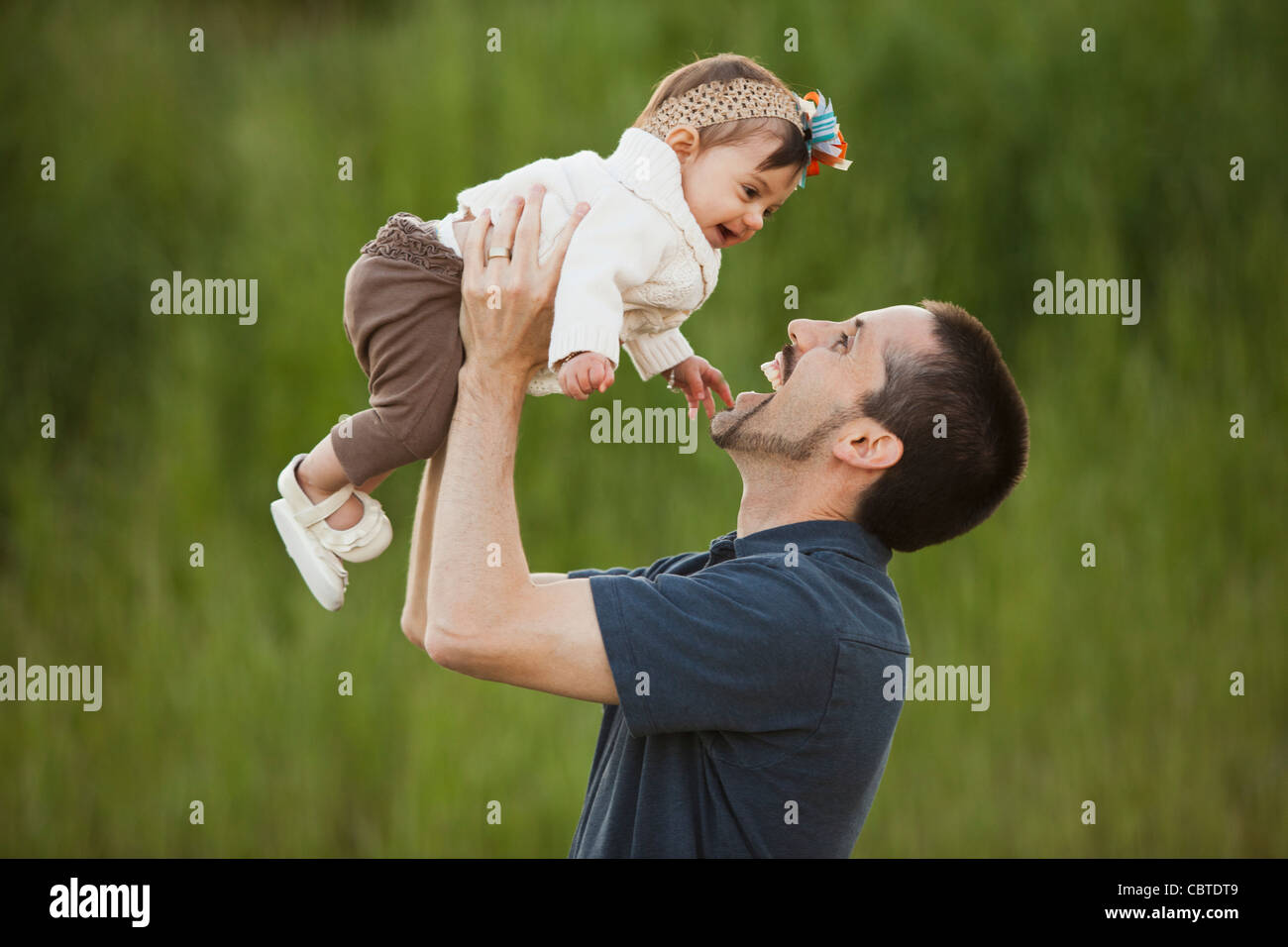 Caucasian father lifting daughter outdoors Stock Photo - Alamy