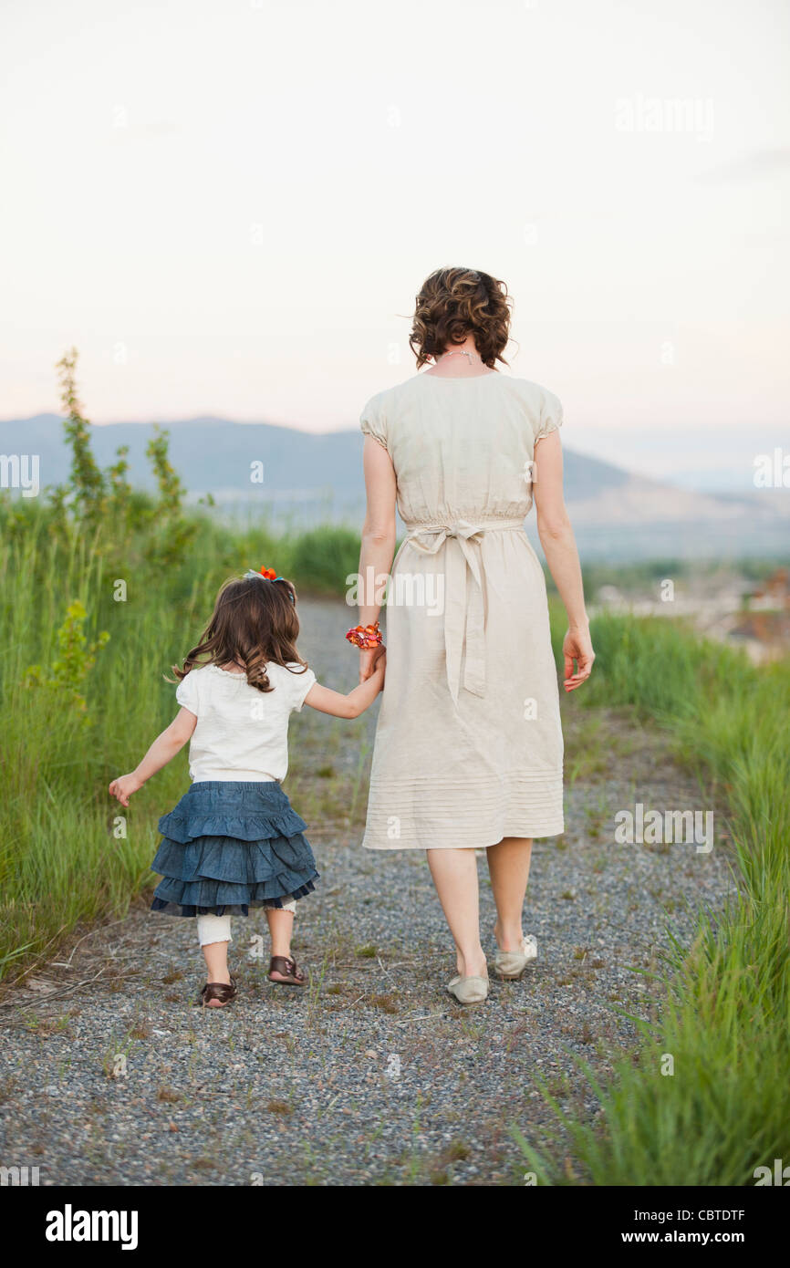 Caucasian mother and daughter walking on path Stock Photo - Alamy