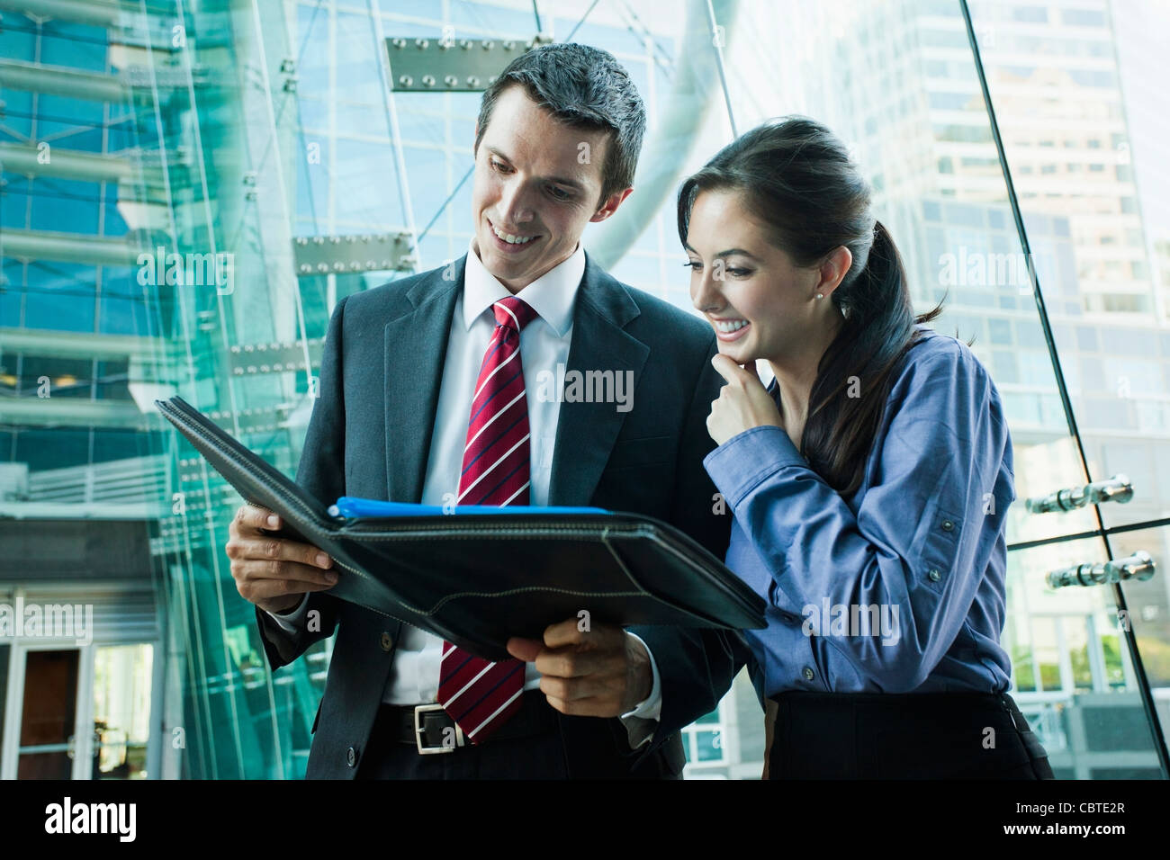 Caucasian business people looking at notebook together Stock Photo - Alamy