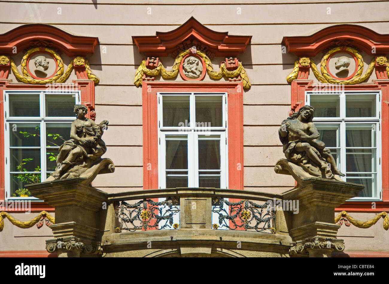 three windows balcony and two sculptures on front of the building in ...