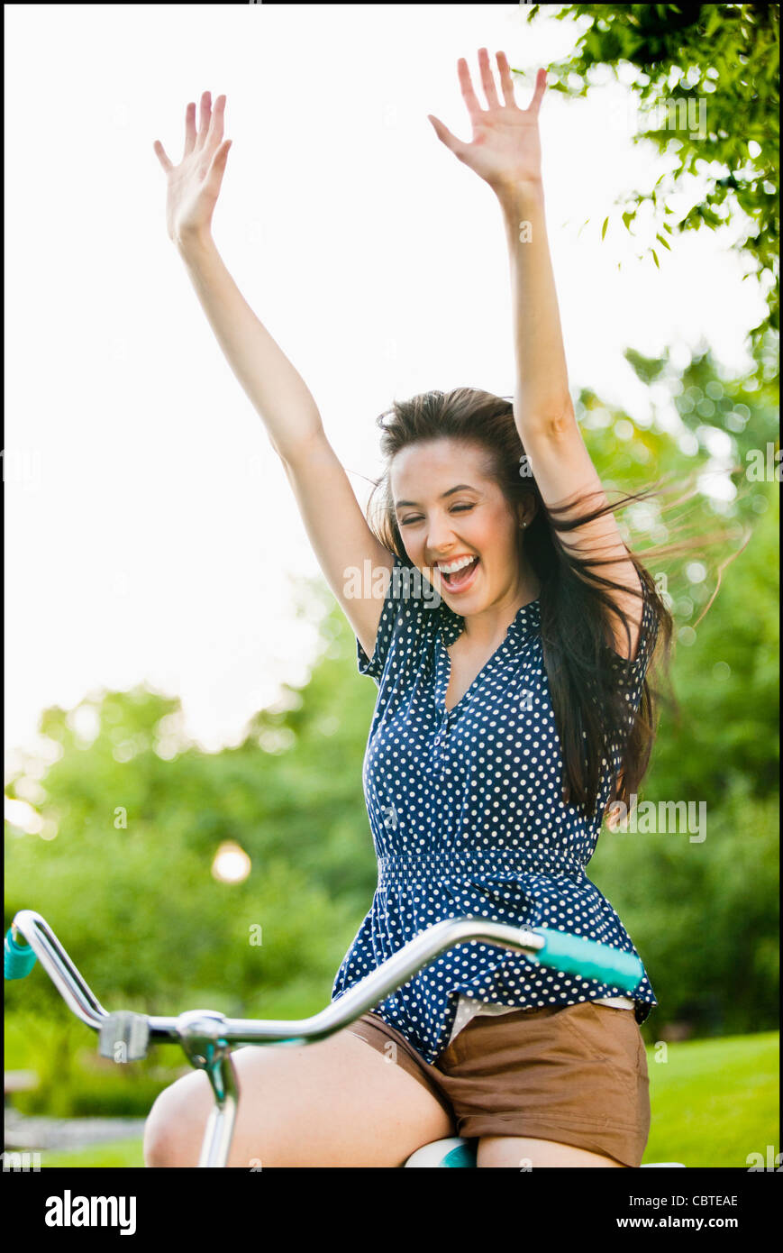 Cheering Caucasian woman cheering on bicycle Stock Photo - Alamy