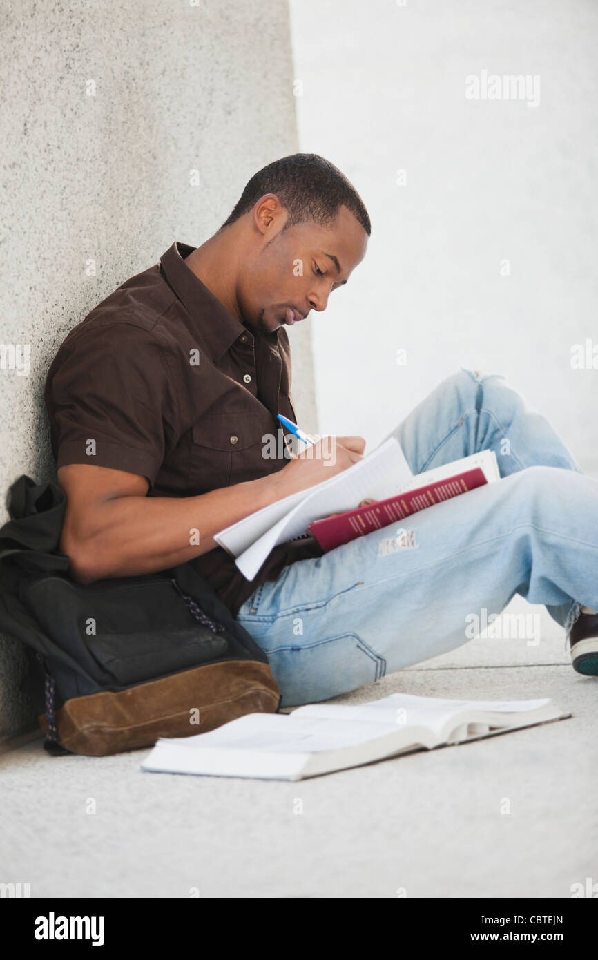 Black college student doing homework outdoor Stock Photo - Alamy