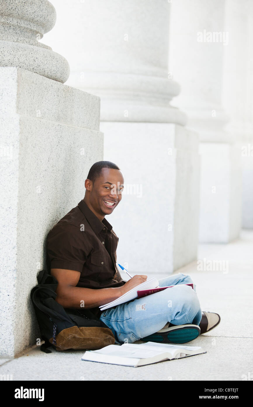 Black college student doing homework outdoor Stock Photo - Alamy