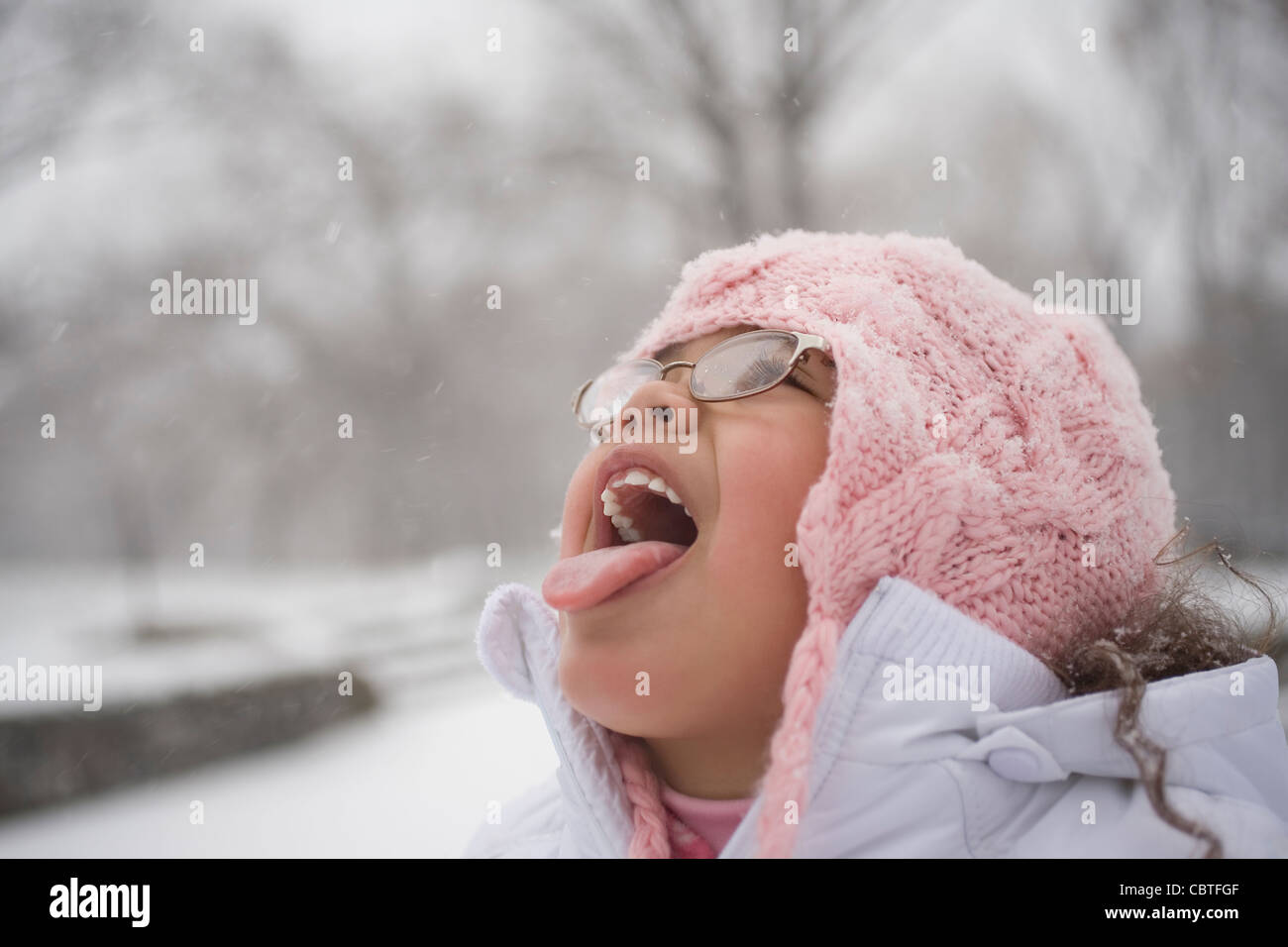 Hispanic girl catching snowflakes on tongue Stock Photo - Alamy