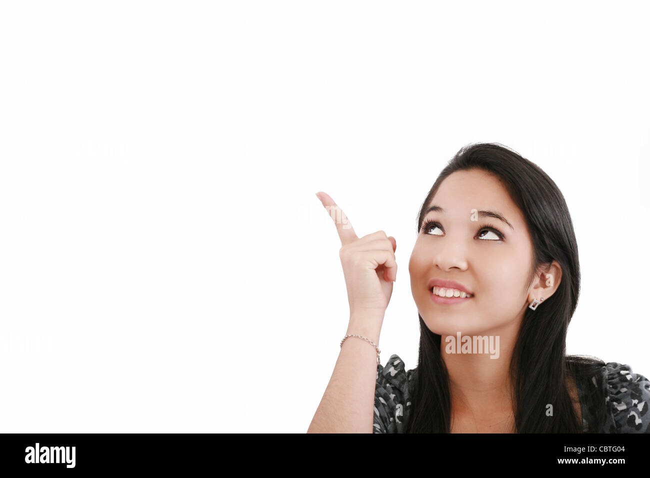 Attractive young woman points to something above her head Stock Photo ...