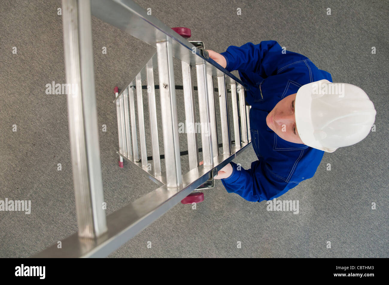 worker in a white helmet, enters the ladder Stock Photo - Alamy