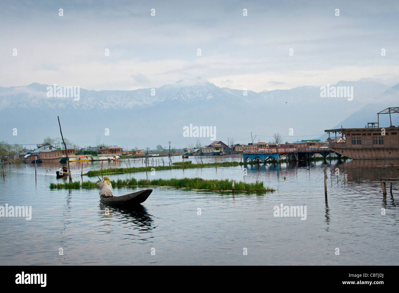 Kashmiri villagers commute in the Nagin Lake of Kashmir, with the snow ...