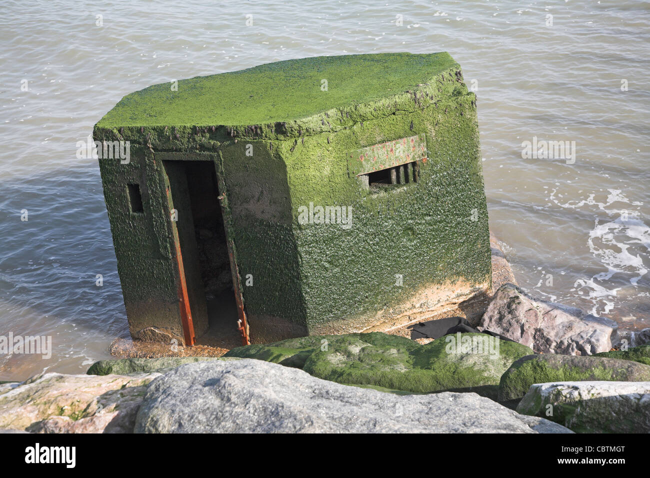 Old pill box fallen into the sea. Coastal erosion and damaged sea ...