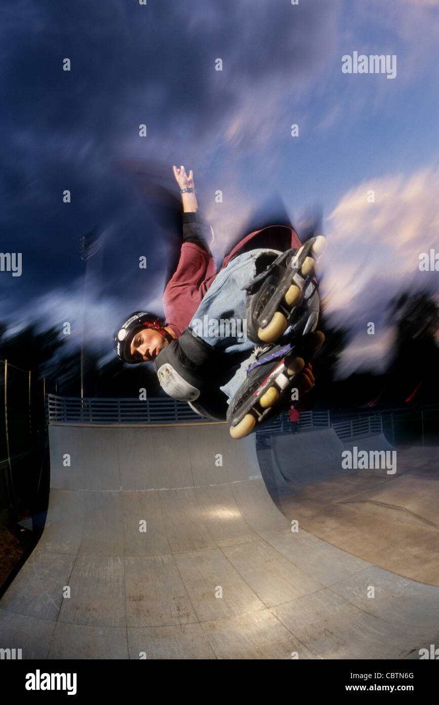 Teenage boy inline skating on the vert ramp Stock Photo - Alamy