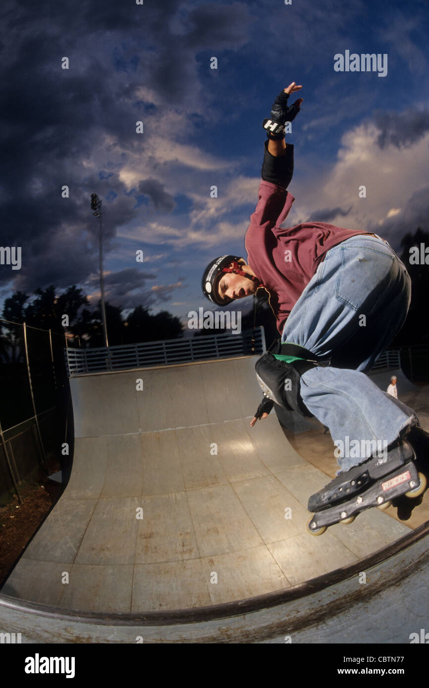 Teenage boy inline skating on the vert ramp Stock Photo - Alamy