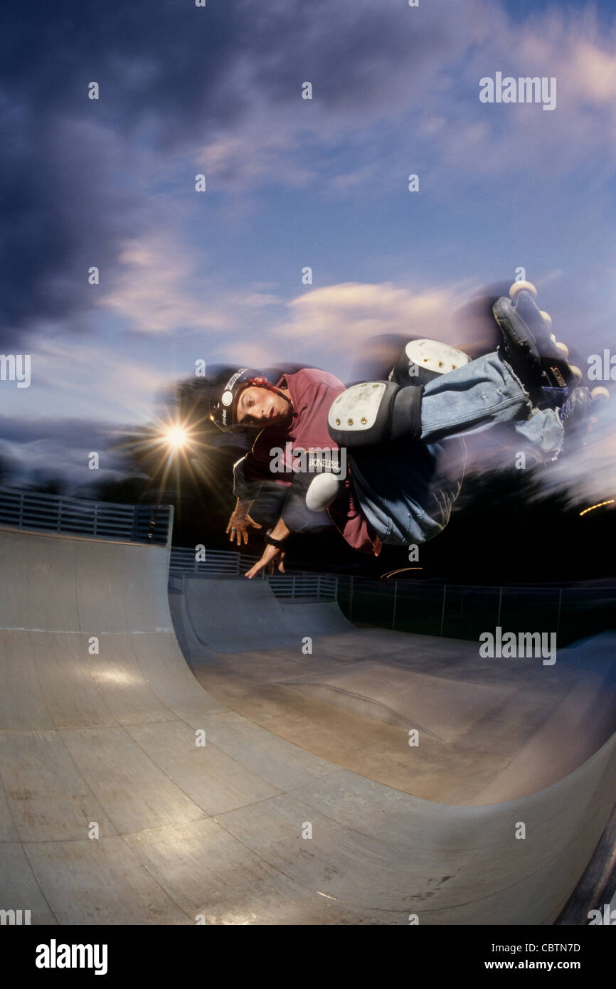 Teenage boy inline skating on the vert ramp Stock Photo - Alamy